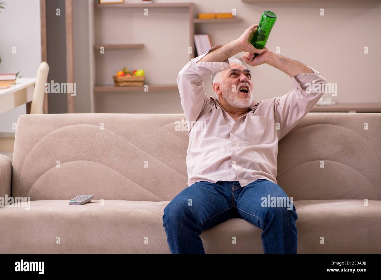 Aged man drinking alcohol at home Stock Photo - Alamy