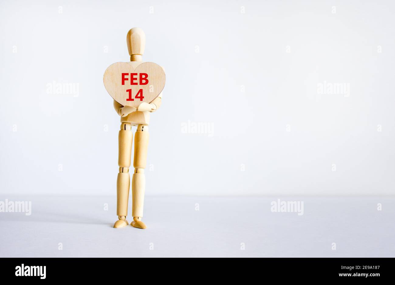 February 14 valentines day symbol. Wooden model of a human holding a ...