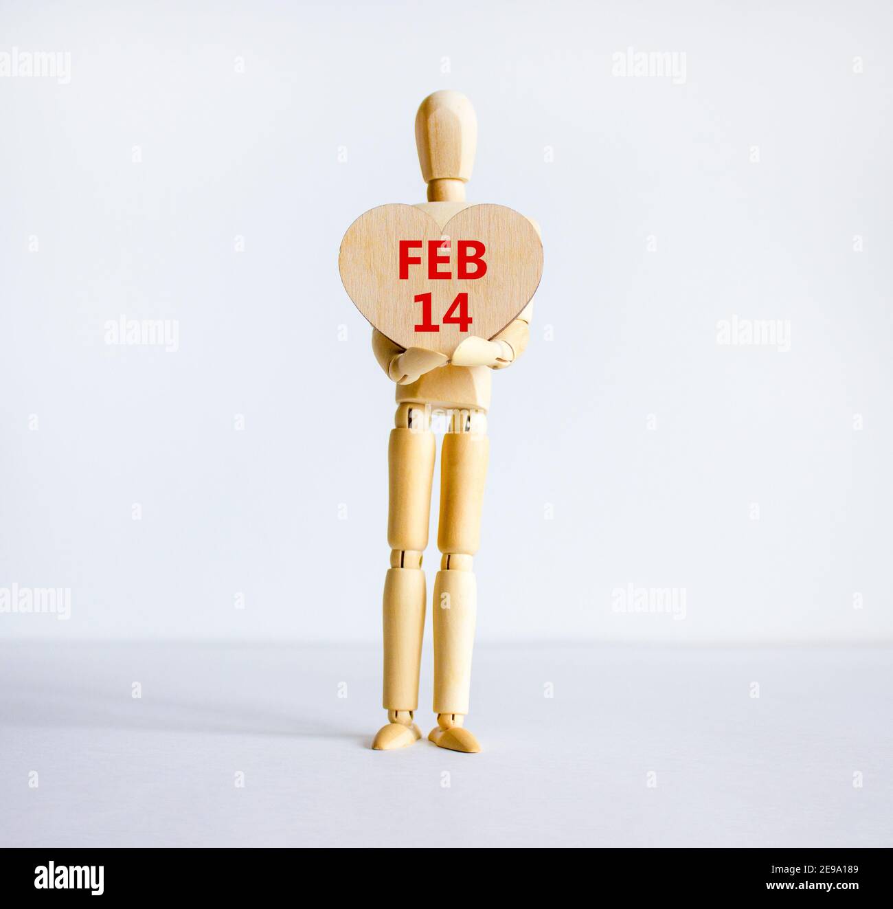 February 14 valentines day symbol. Wooden model of a human holding a ...