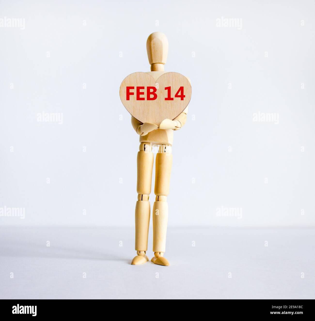 February 14 valentines day symbol. Wooden model of a human holding a ...