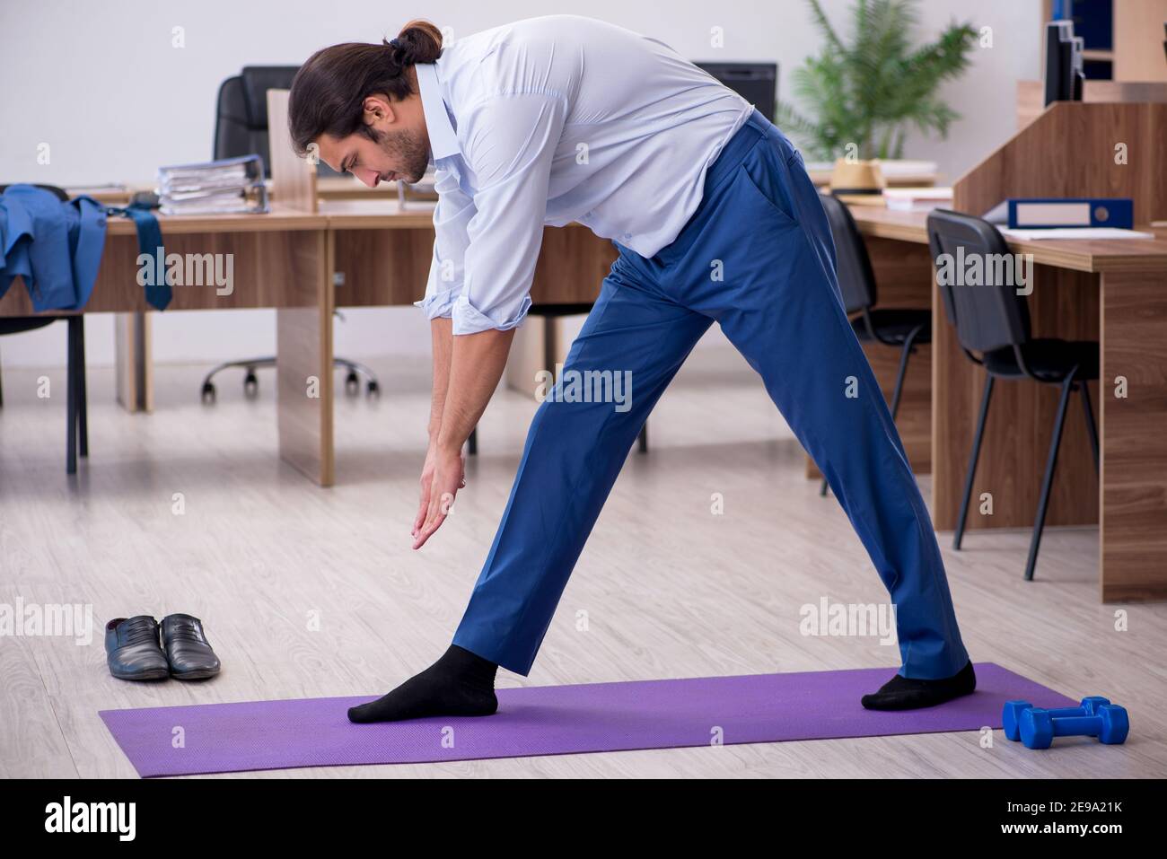 Young employee doing sport exercises during break Stock Photo - Alamy