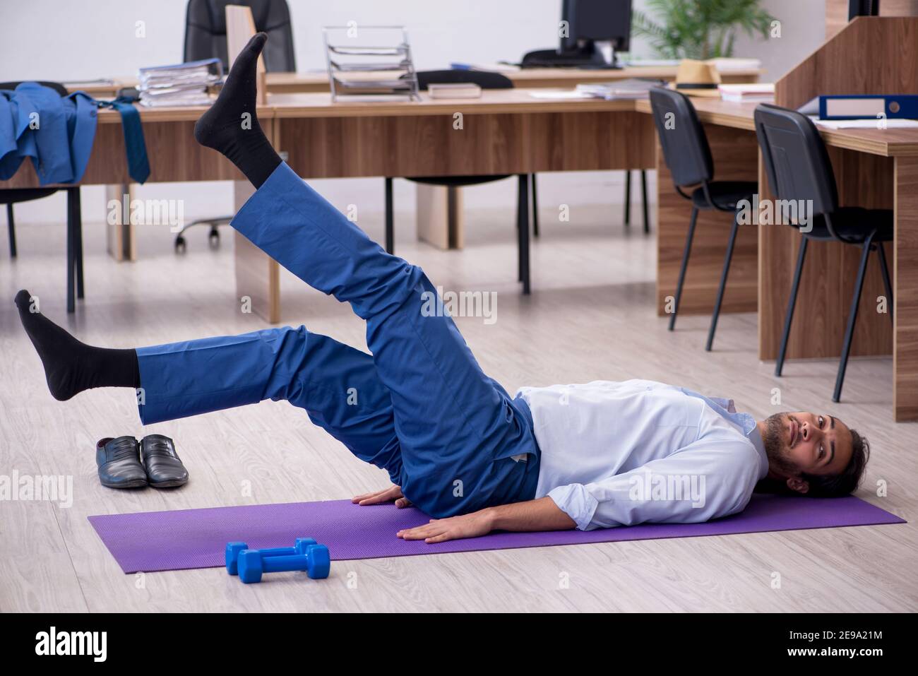 Young employee doing sport exercises during break Stock Photo - Alamy
