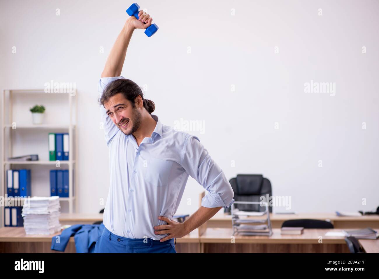 Young employee doing sport exercises during break Stock Photo - Alamy
