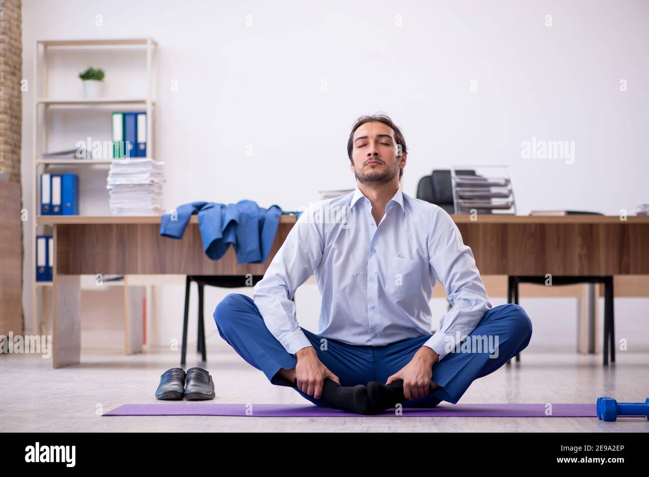 Young employee doing sport exercises during break Stock Photo - Alamy