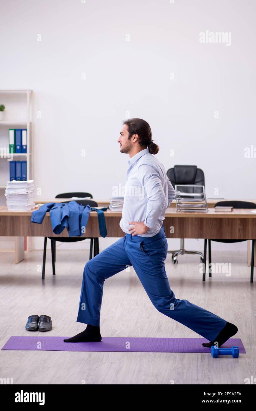 Young employee doing sport exercises during break Stock Photo - Alamy