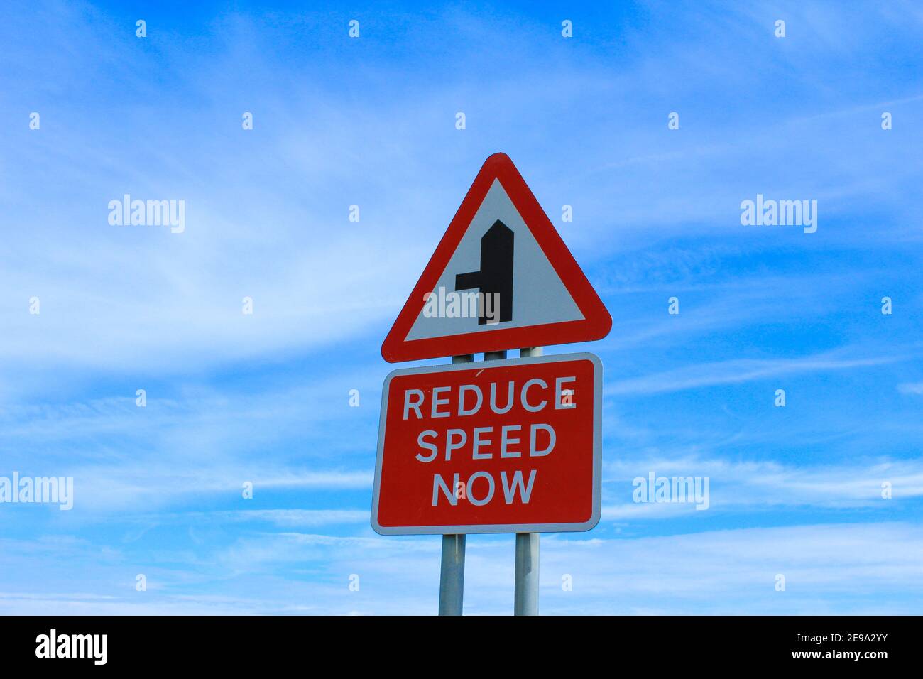 Road traffic reduce speed now warning sign against nice sky background ...