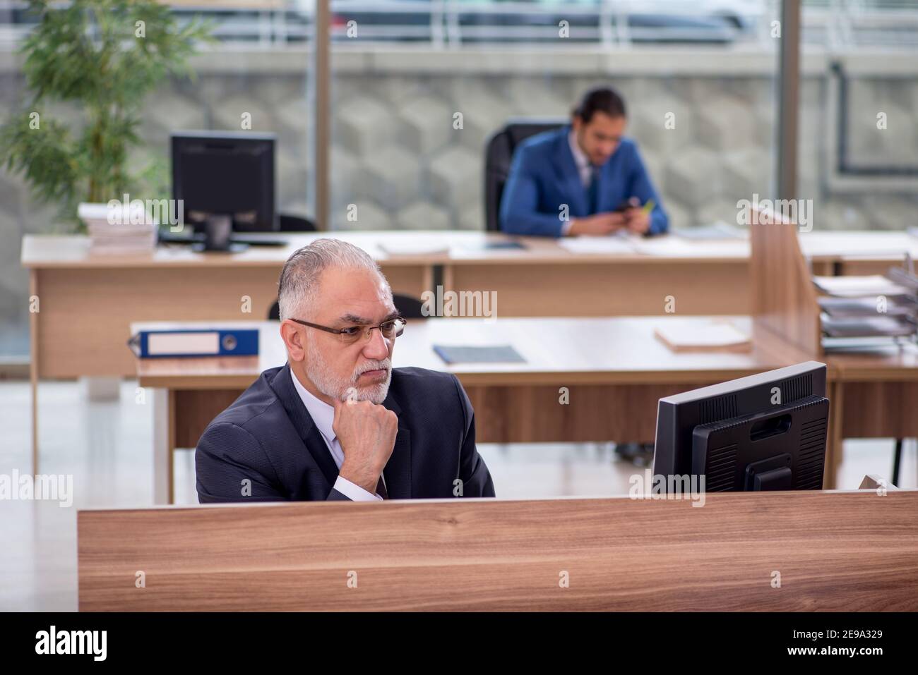 Two businessmen employees sitting in the office Stock Photo - Alamy