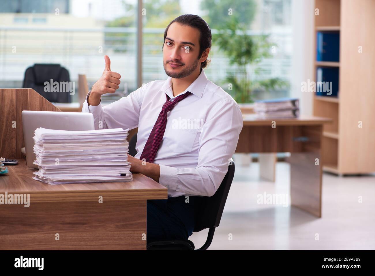Young employee and too many work in the office Stock Photo - Alamy