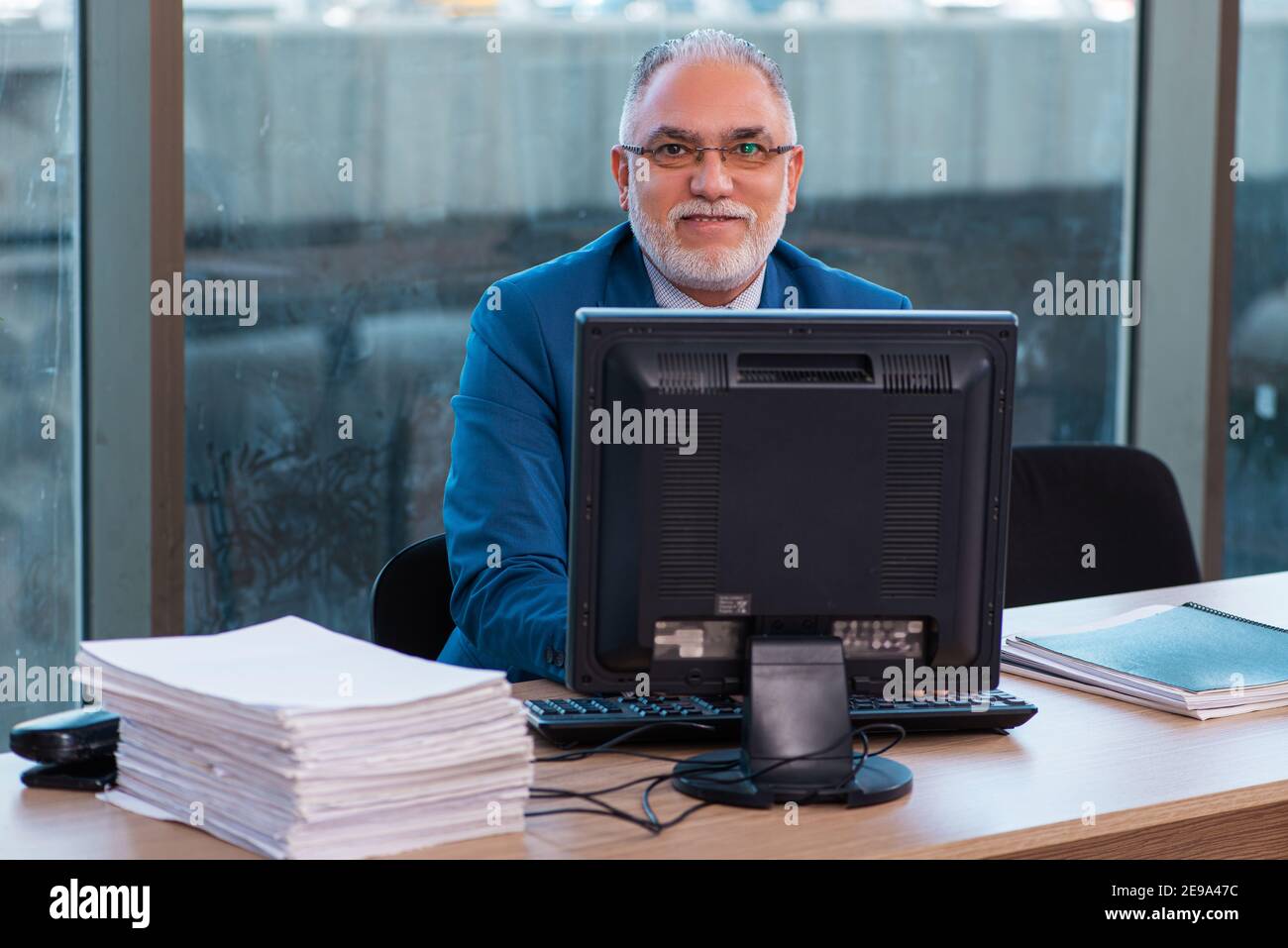 Old employee working in the office Stock Photo - Alamy