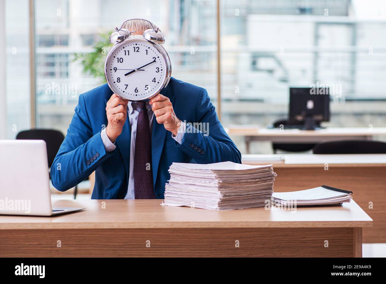 Old boss employee in time management concept Stock Photo - Alamy