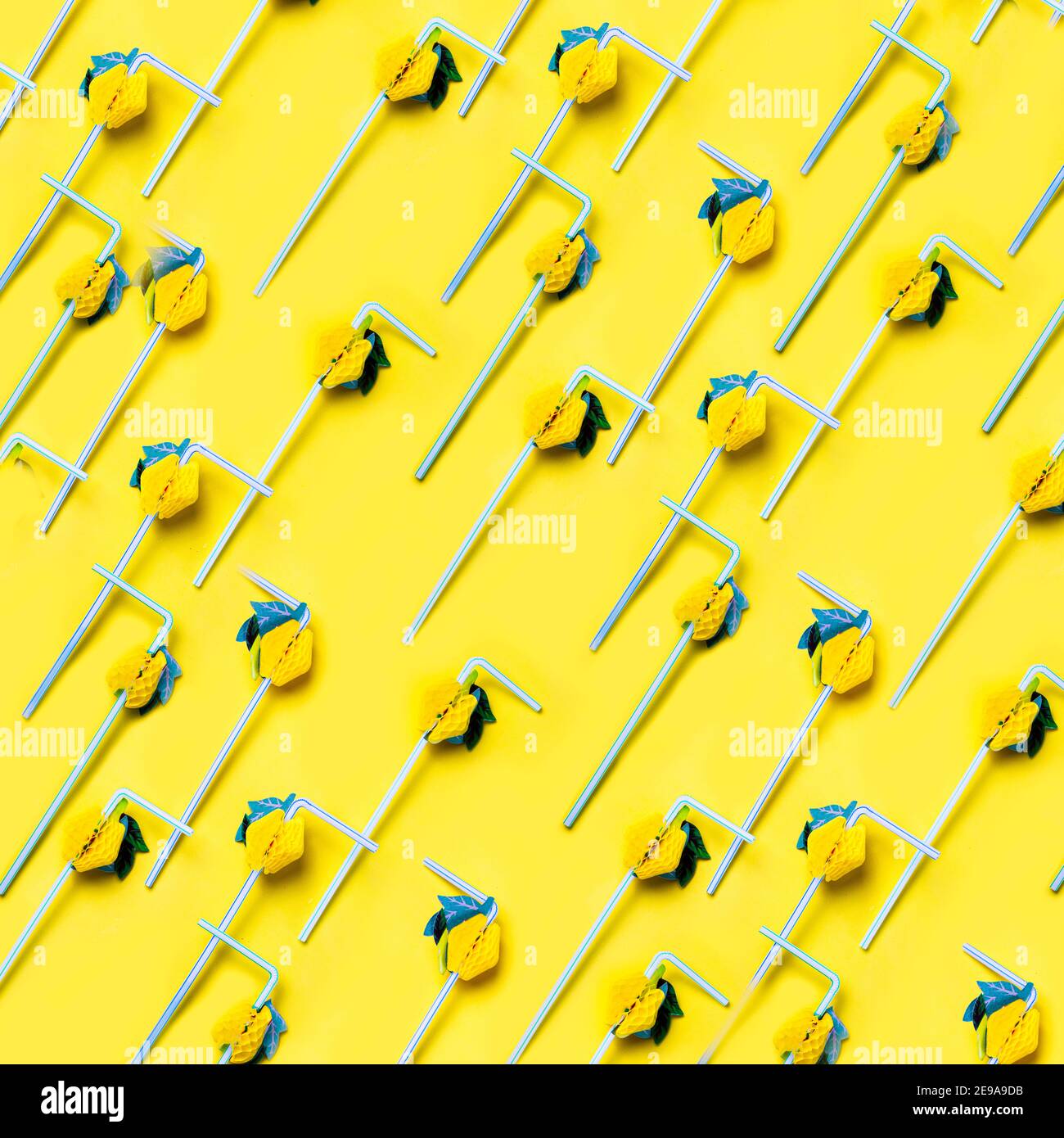 a pattern of straws with yellow lemon-shaped head on yellow background ...