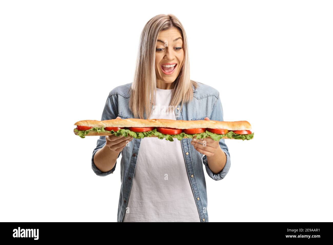 Hungry young woman with a tasty long sandwich in a baguette isolated on ...