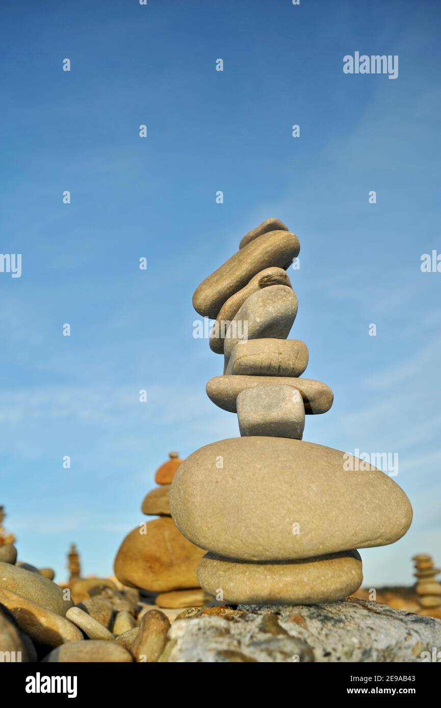 Smooth, oddly shaped rocks and stones piled up tall, balanced ...