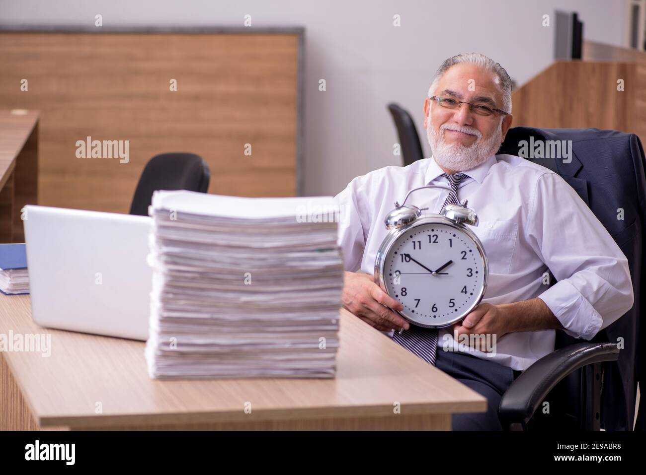 Old employee in time manegement concept Stock Photo - Alamy