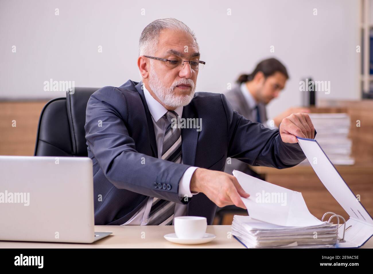 Old male boss and young male assistant in the office Stock Photo - Alamy
