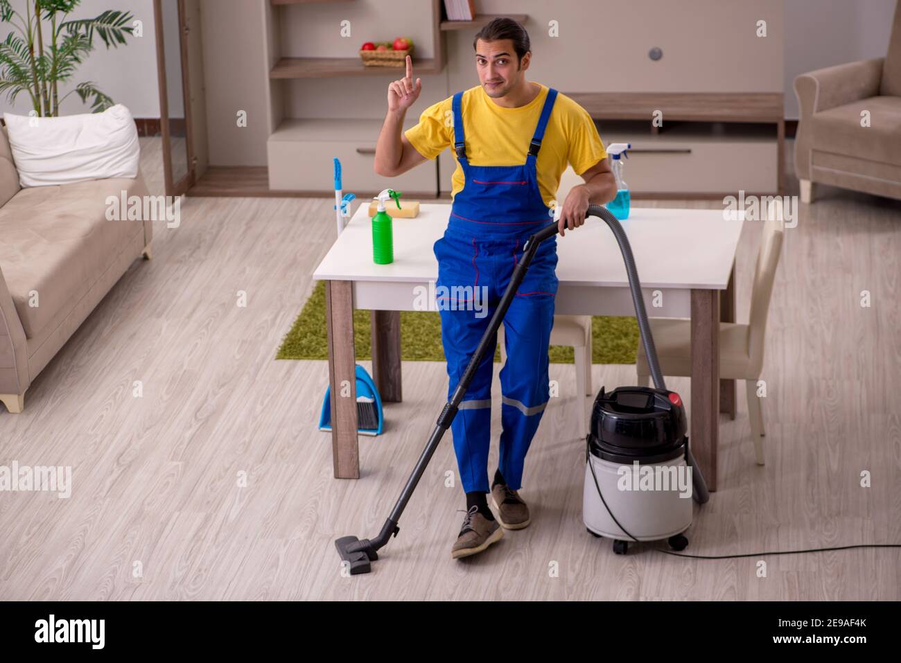 Young contractor cleaning the house Stock Photo - Alamy