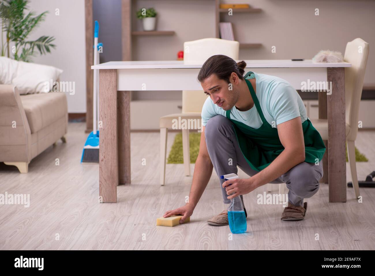 Young contractor cleaning the house Stock Photo - Alamy