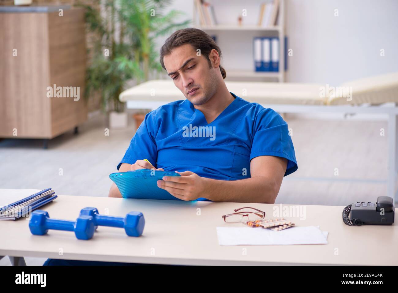 Young doctor physiotherapist doing sport exercises Stock Photo - Alamy