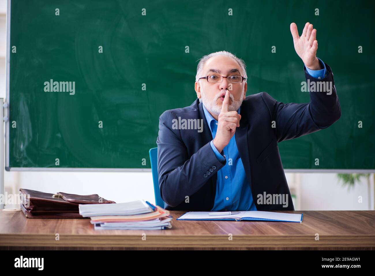 Aged male math teacher in the classroom Stock Photo - Alamy