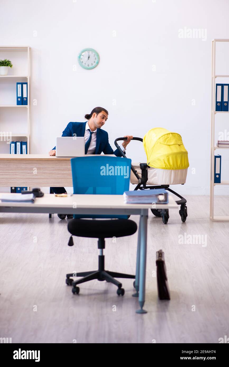 Young employee looking after kid at workplace Stock Photo - Alamy