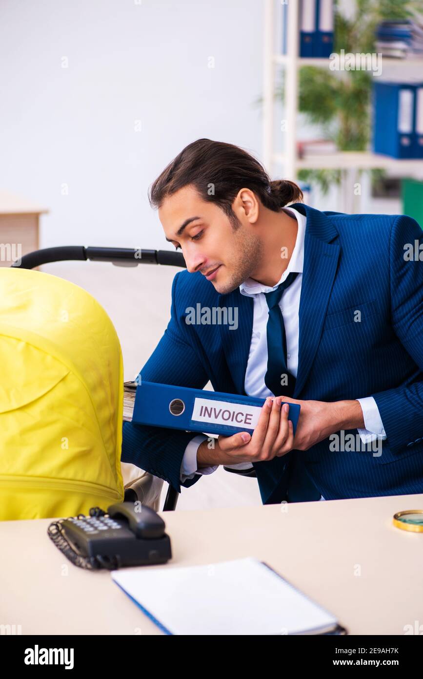 Young employee looking after kid at workplace Stock Photo - Alamy