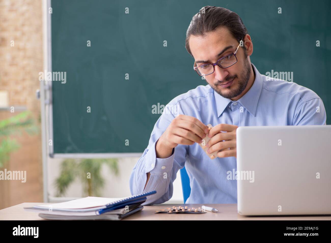 Young sick teacher in the classroom Stock Photo - Alamy