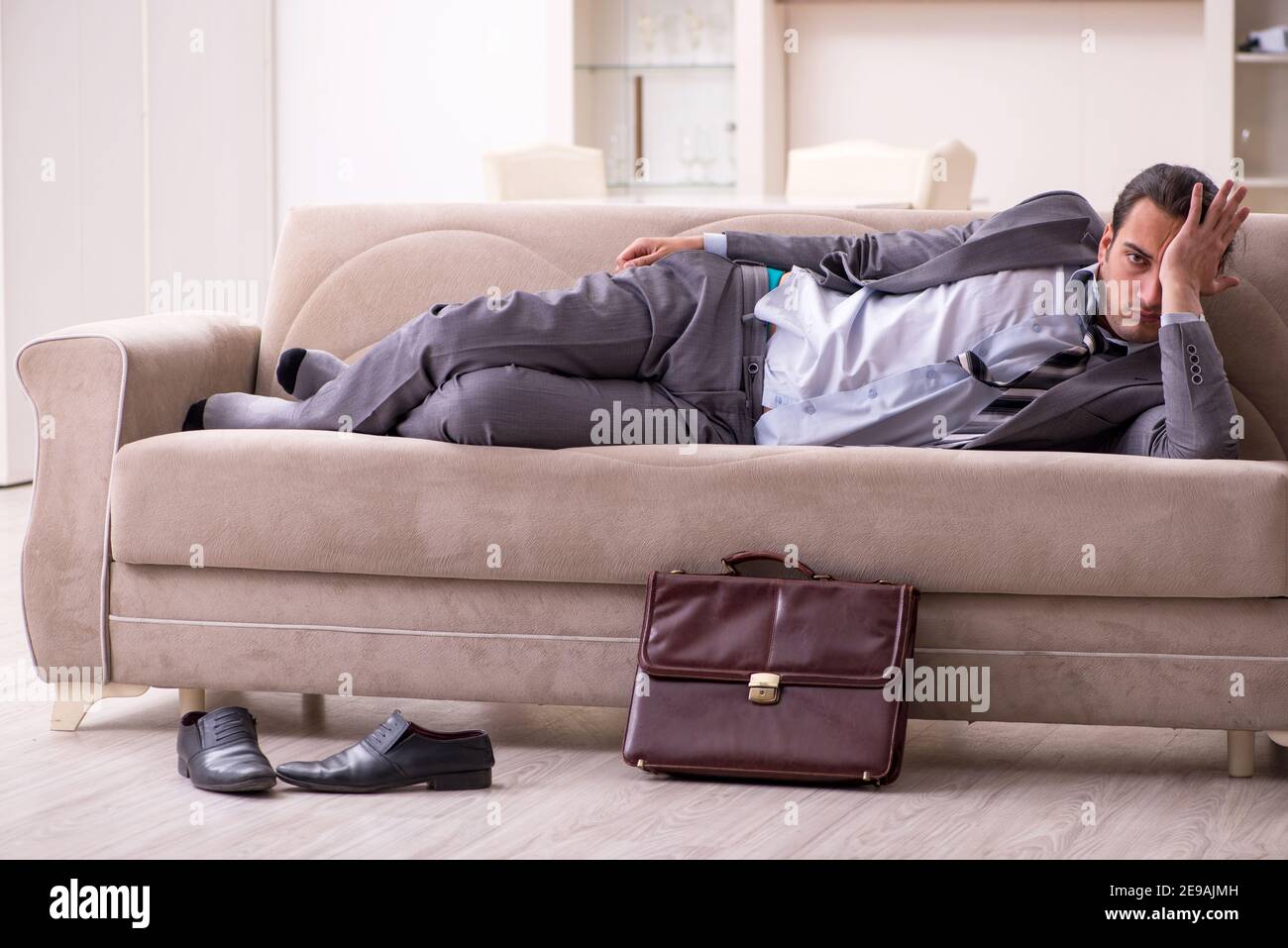 Tired businessman coming home after working day Stock Photo - Alamy