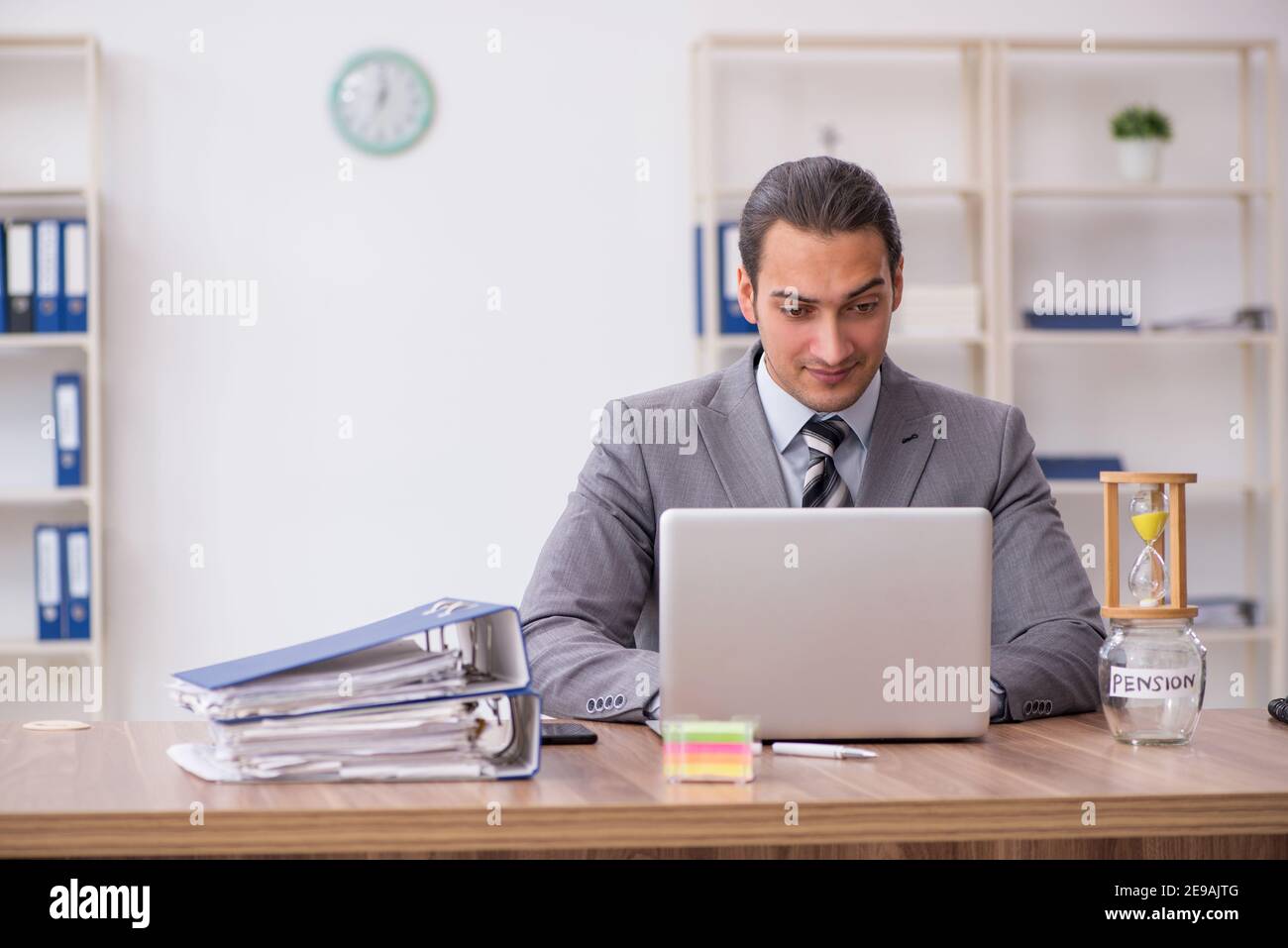 Young employee in pension concept at workplace Stock Photo - Alamy