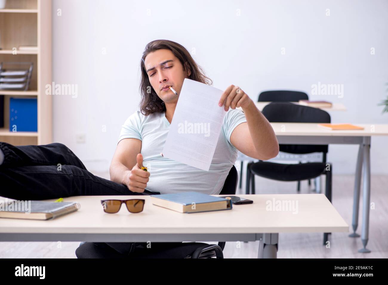 Male unhappy student burning exam paper in the classroom Stock Photo ...
