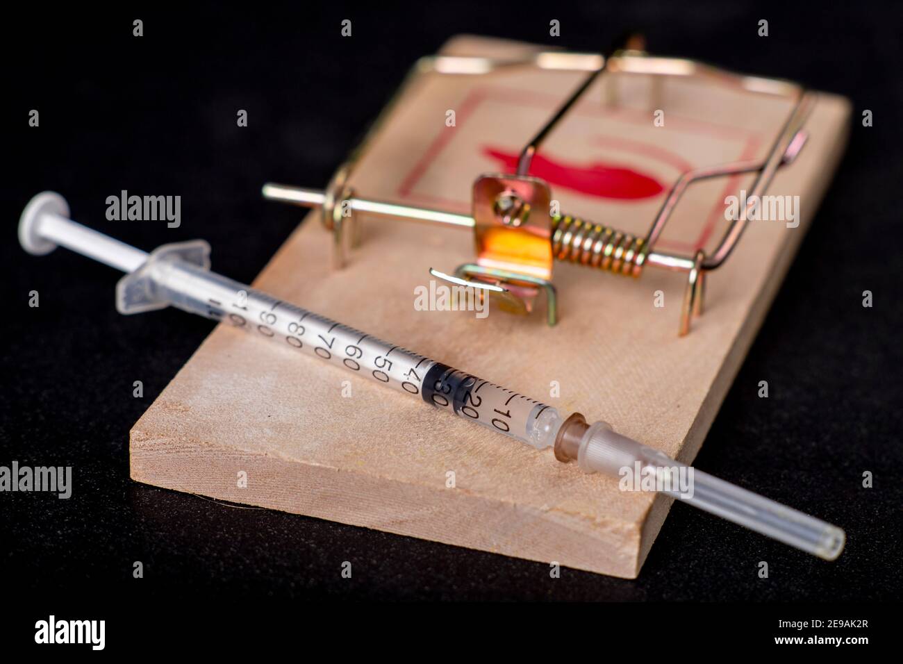 A syringe with the vaccine placed in a mouse paw. A trap in the form of ...