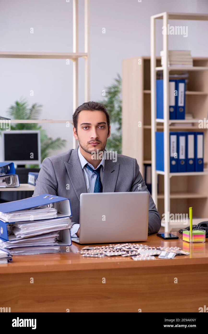 Male sick employee suffering at workplace Stock Photo - Alamy