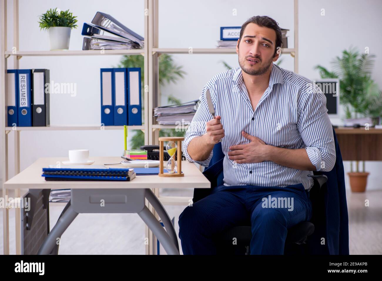 Hungry employee waiting for food in time management concept Stock Photo ...