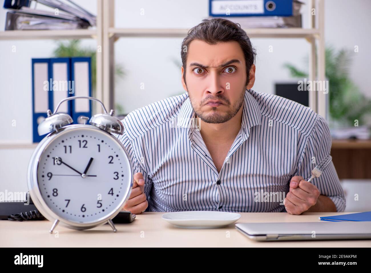 Hungry employee waiting for food in time management concept Stock Photo ...