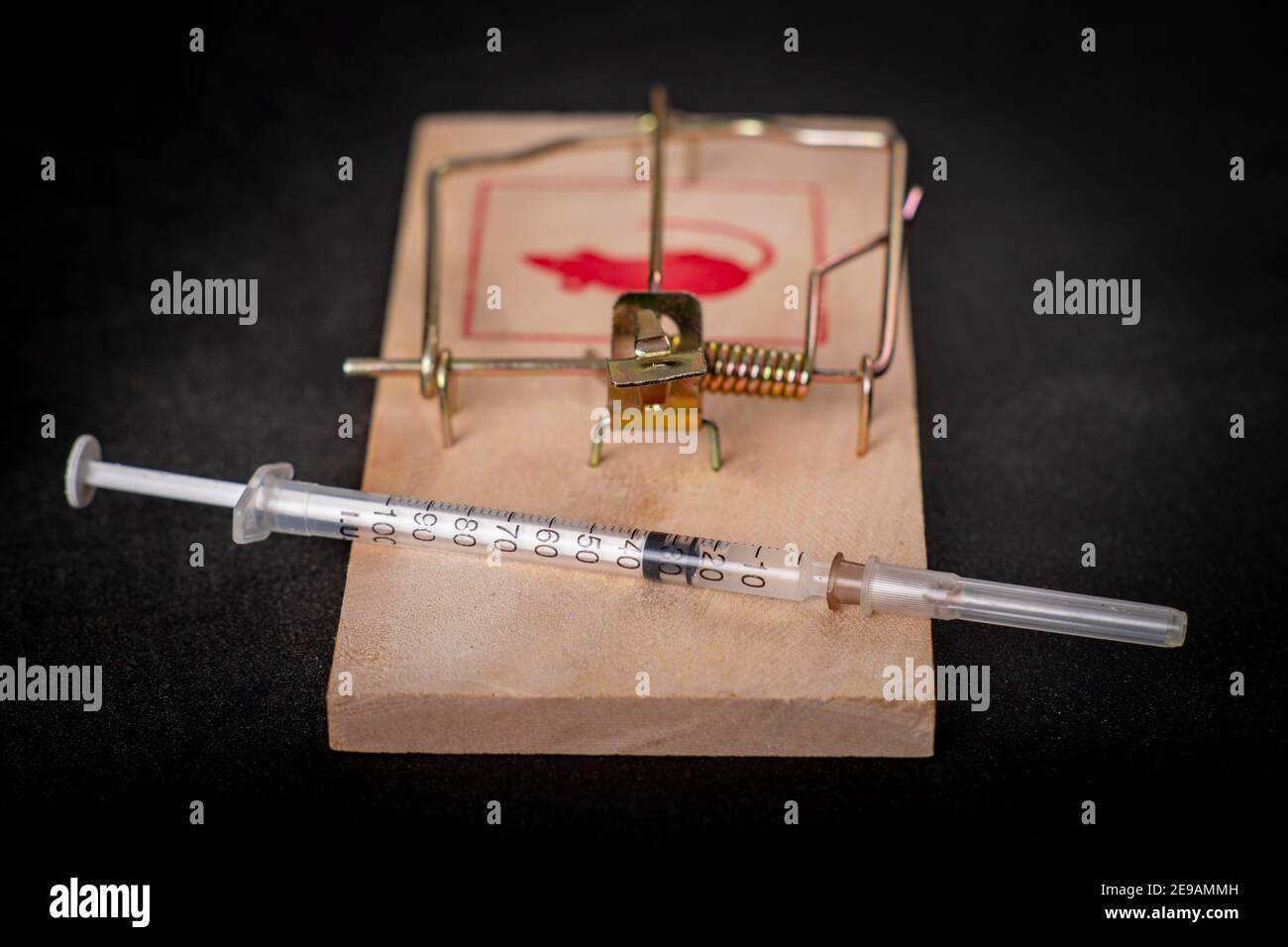 A syringe with the vaccine placed in a mouse paw. A trap in the form of ...