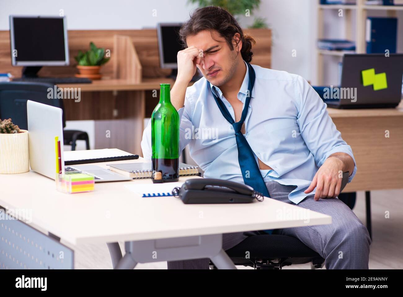 Male employee drinking alcohol at workplace Stock Photo - Alamy