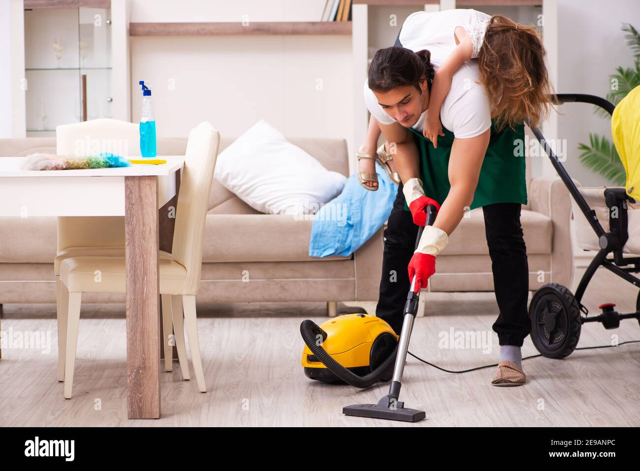 Young contractor cleaning the house with his small daughter Stock Photo ...