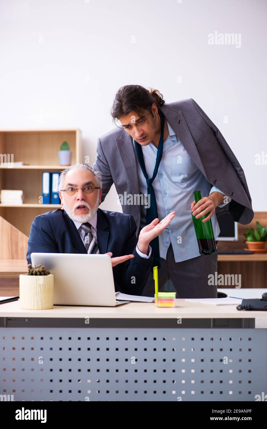 Old boss and young alcoholic employee in the office Stock Photo - Alamy