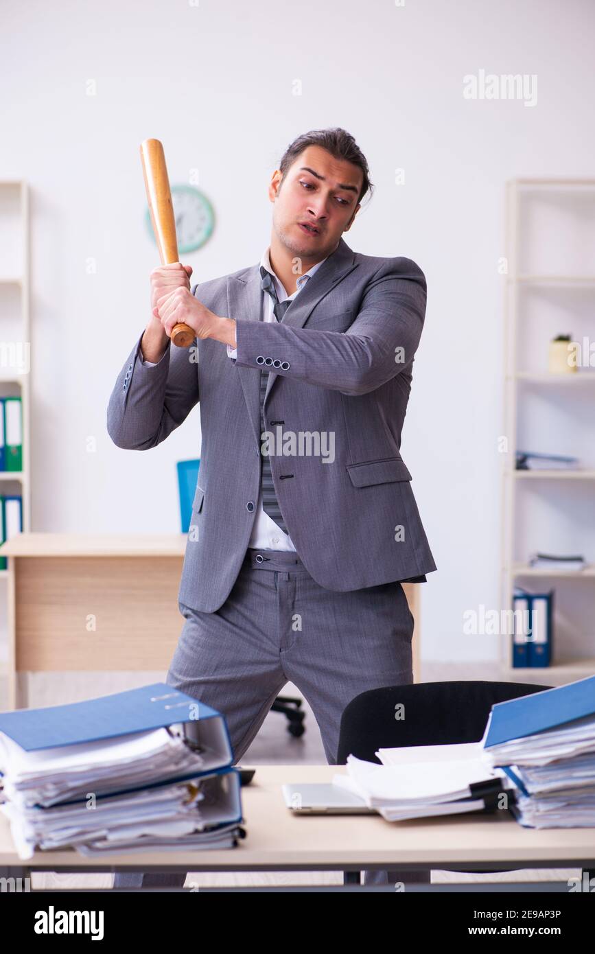 Male employee angry with excessive work holding baseball bat Stock ...