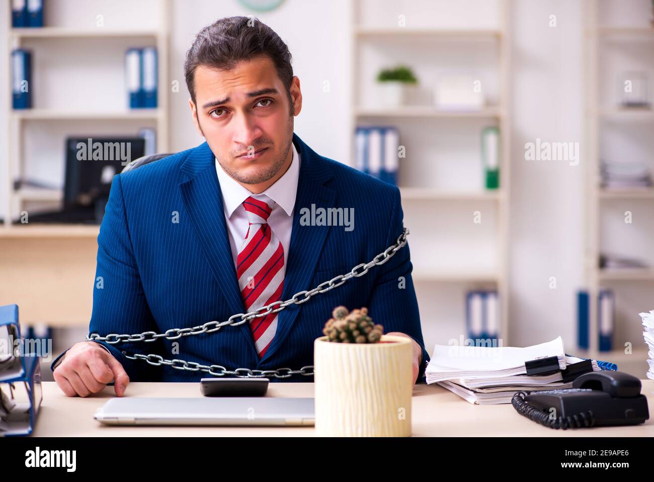Chained employee working in the office Stock Photo - Alamy