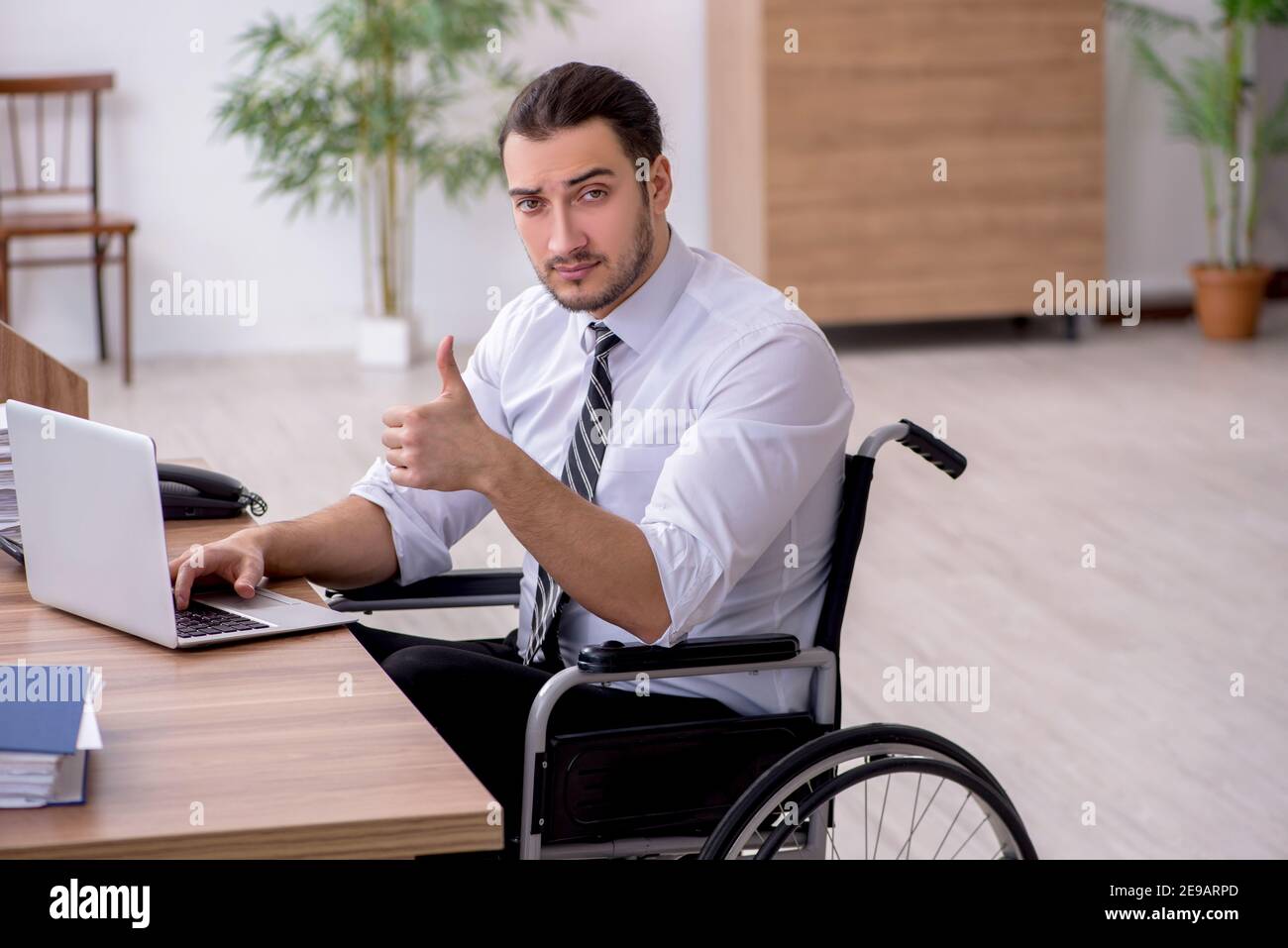 Young disabled employee suffering at the workplace Stock Photo - Alamy