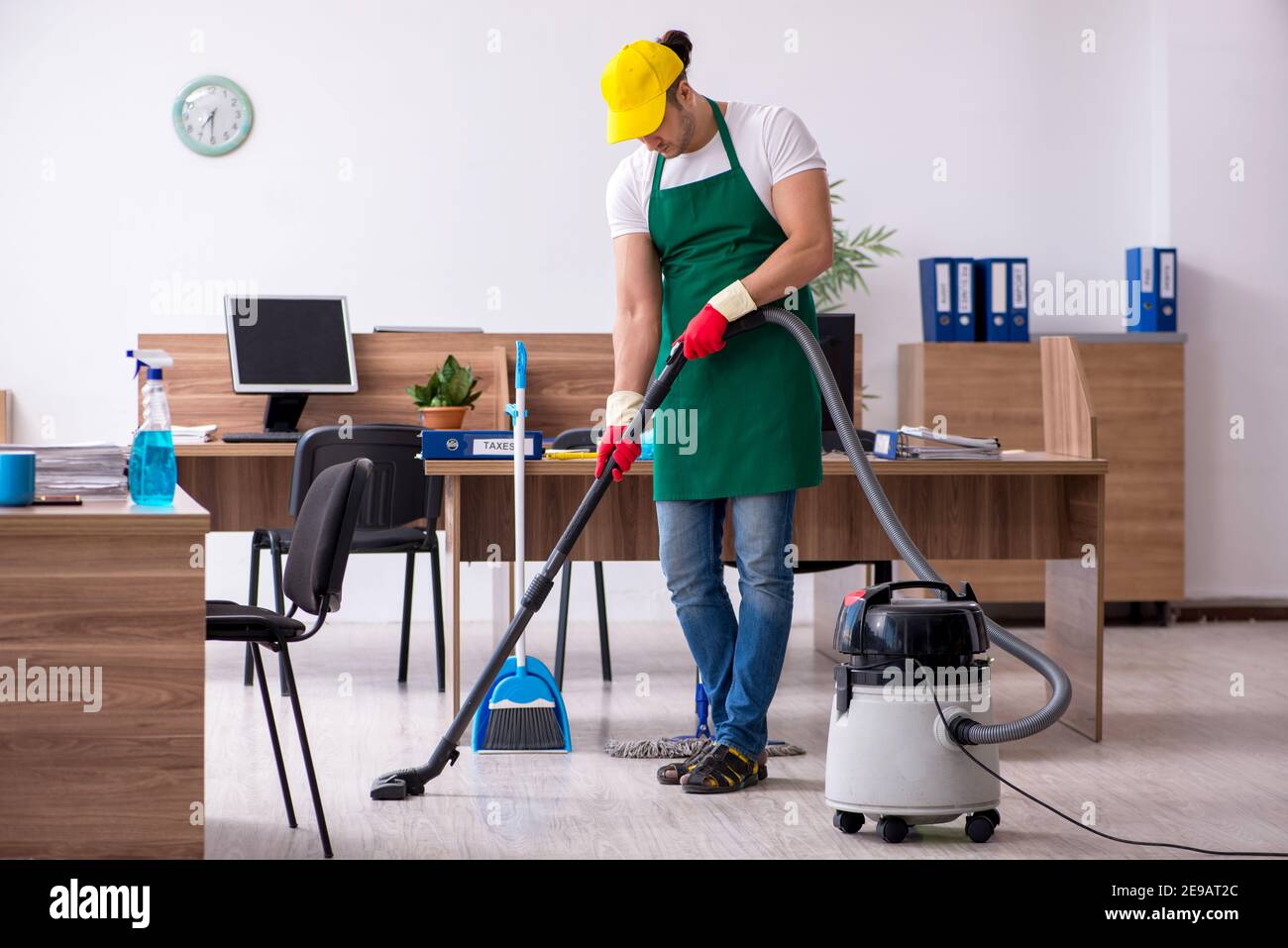Young contractor cleaning the office Stock Photo - Alamy
