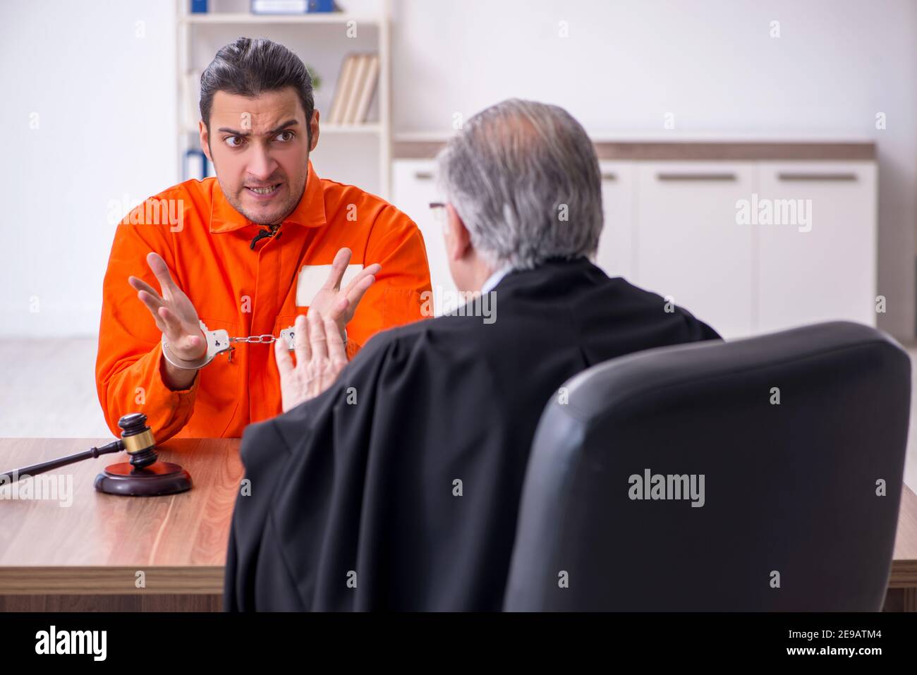 Old judge meeting with young captive in courthouse Stock Photo - Alamy