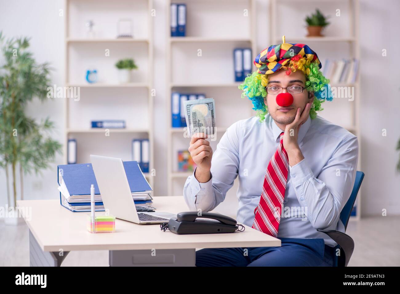 Funny employee clown working in the office room Stock Photo - Alamy