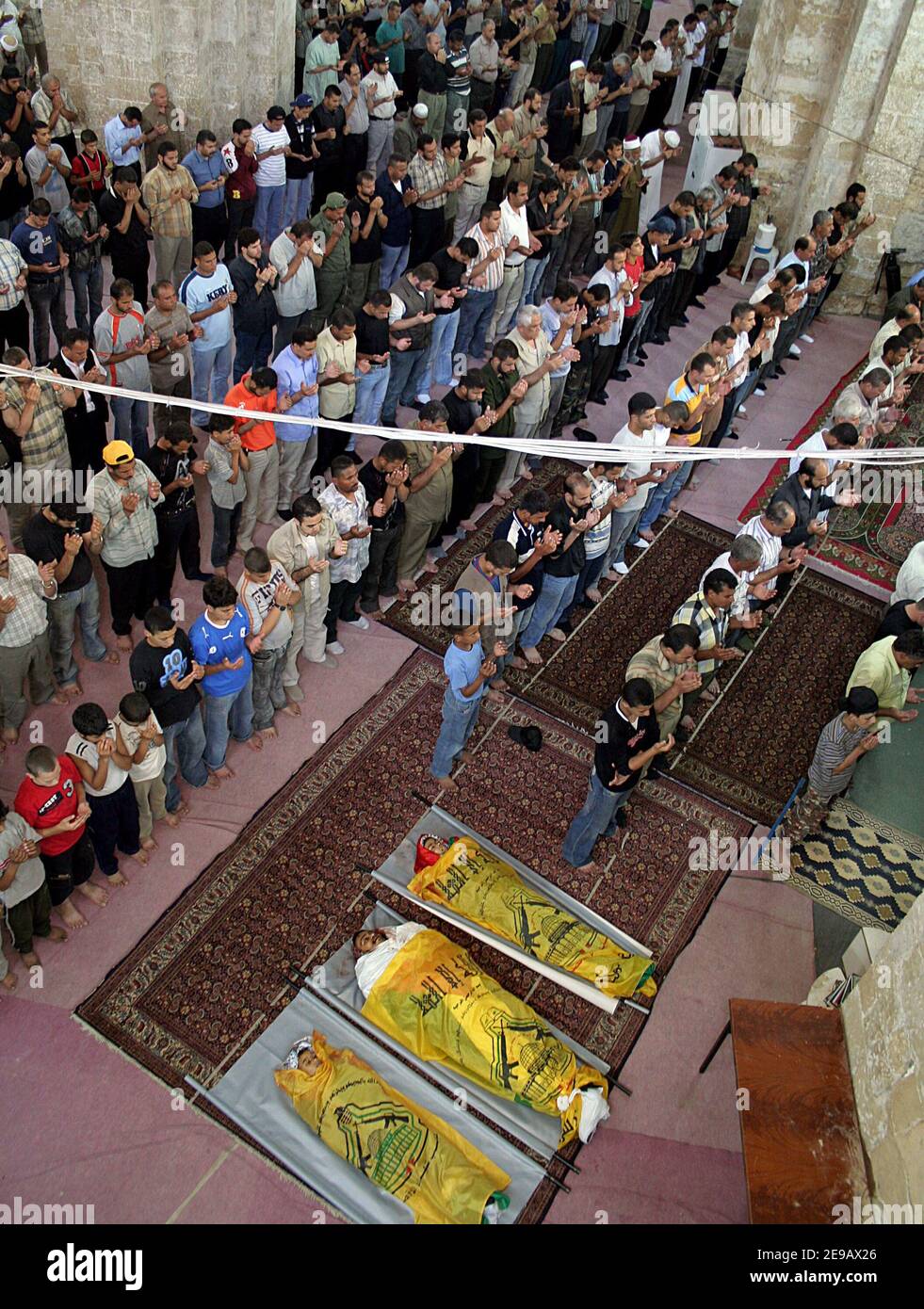 Palestinians mourn over the bodies of Ashraf al-Mughrabi and his two ...