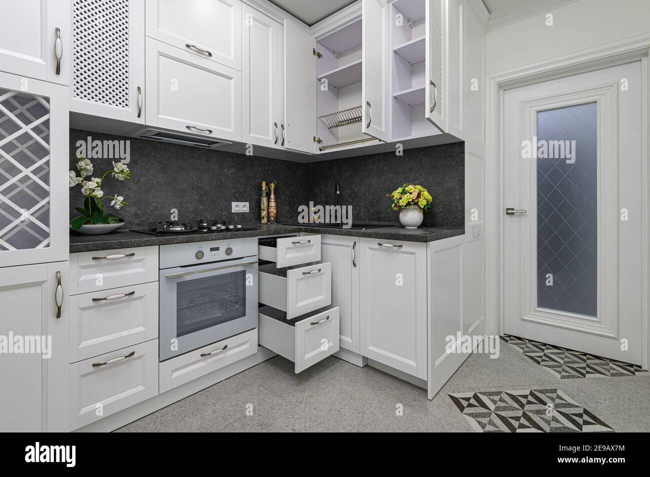 Open doors and drawers open at modern white kitchen Stock Photo - Alamy