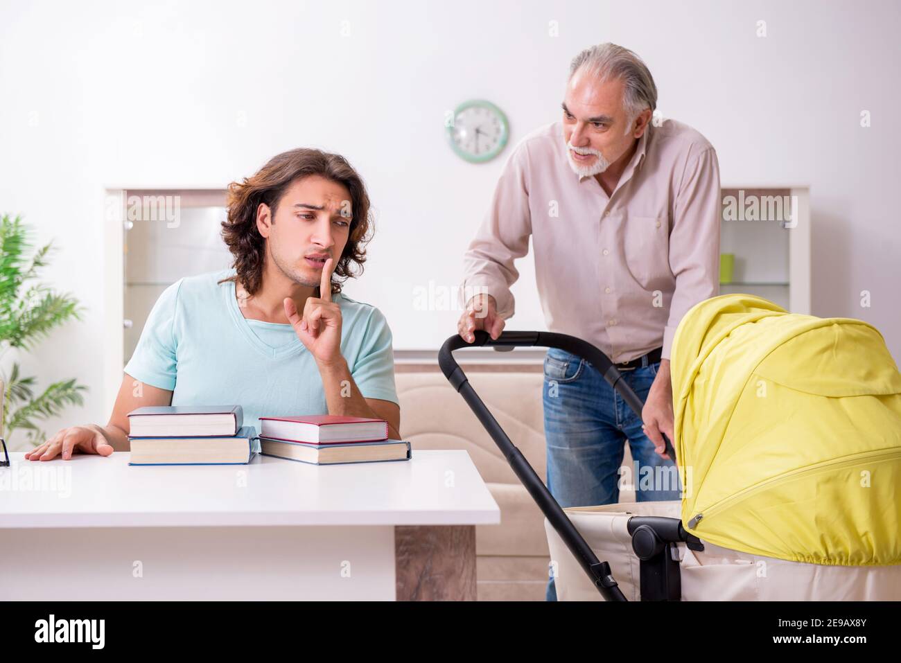 Old grandfather looking after newborn at home Stock Photo - Alamy