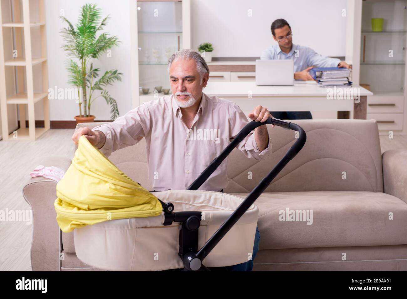 Old grandfather looking after newborn at home Stock Photo - Alamy