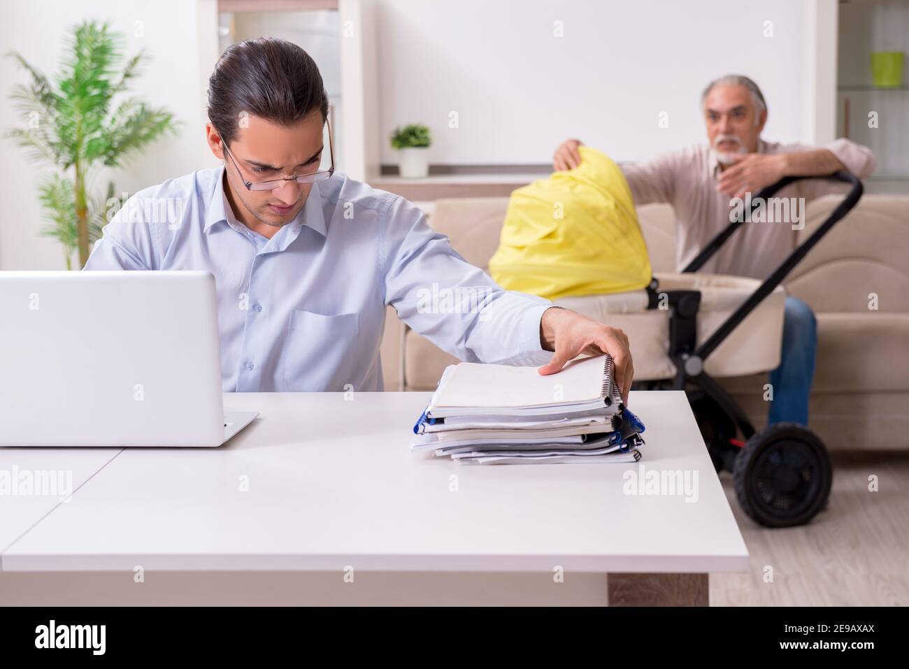 Old grandfather looking after newborn at home Stock Photo - Alamy