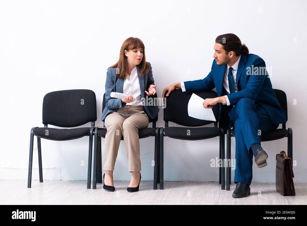 Businessman and businesswoman waiting for an interview at hall Stock ...