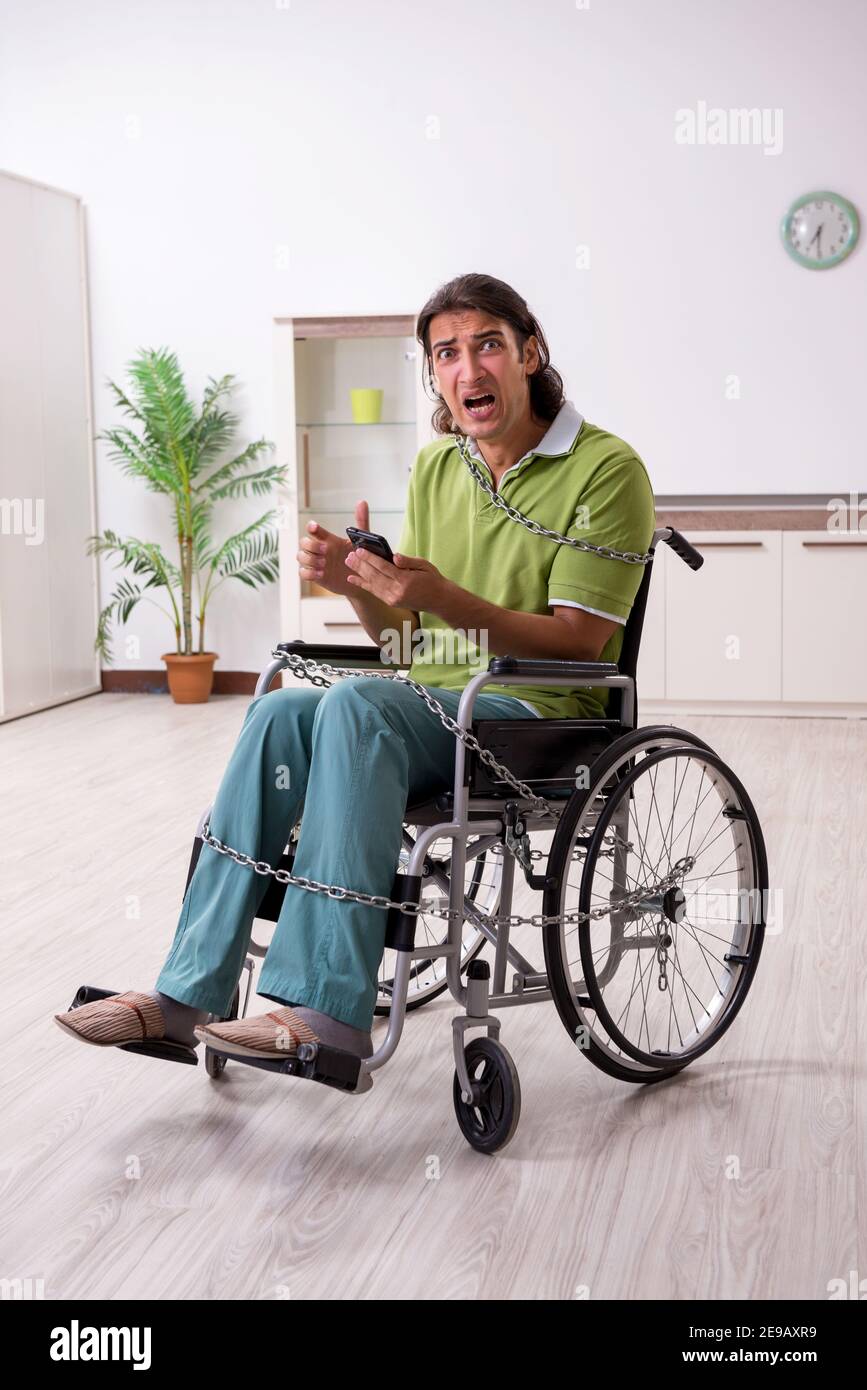The young male invalid in wheel-chair suffering at home Stock Photo - Alamy